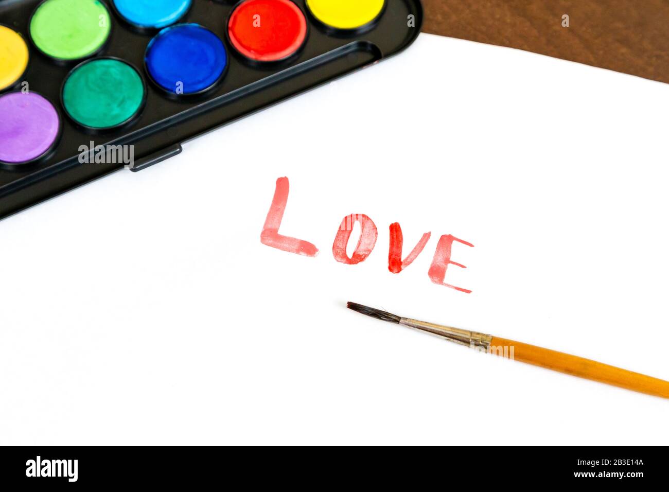 Handwritten LOVE text with brush and watercolor paints on white ...