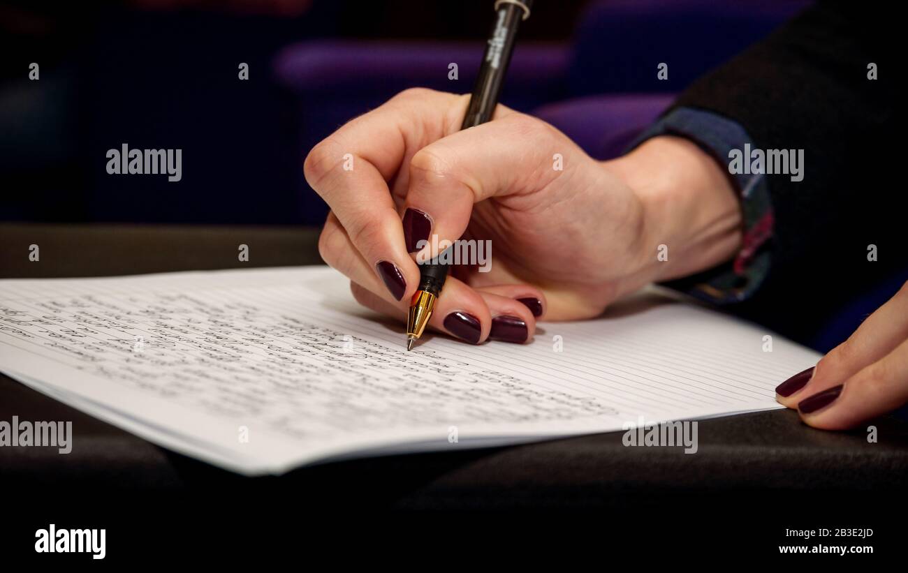 The human hand that writes text on a sheet of white paper, caligraphy ...