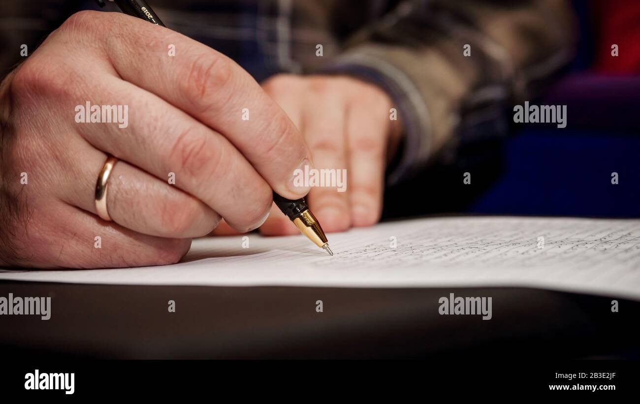 The human hand that writes text on a sheet of white paper, caligraphy ...