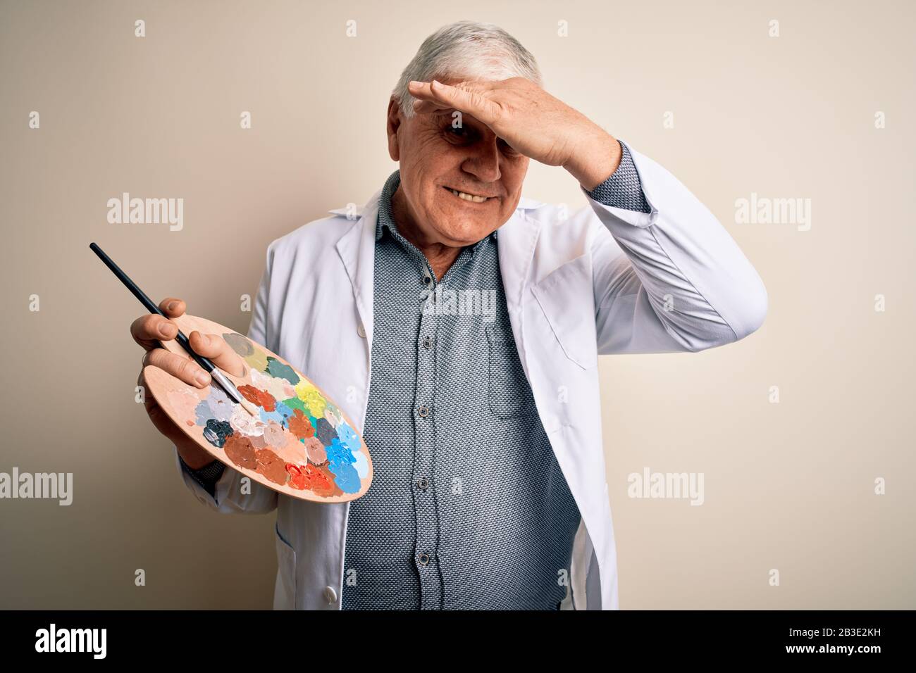 Senior handsome hoary painter man painting using brush and palette with ...