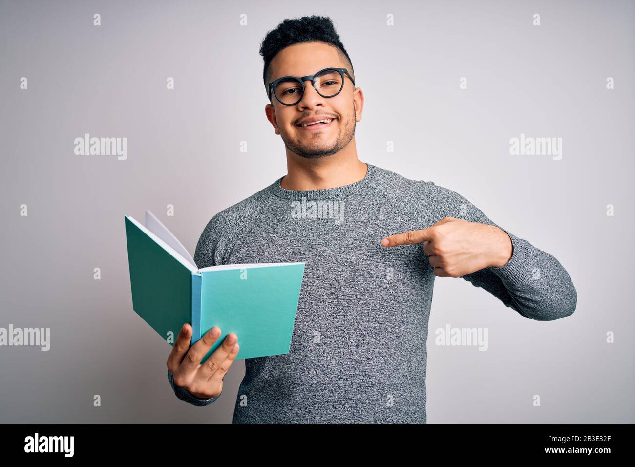Young handsome smart student man reading book over isolated white ...