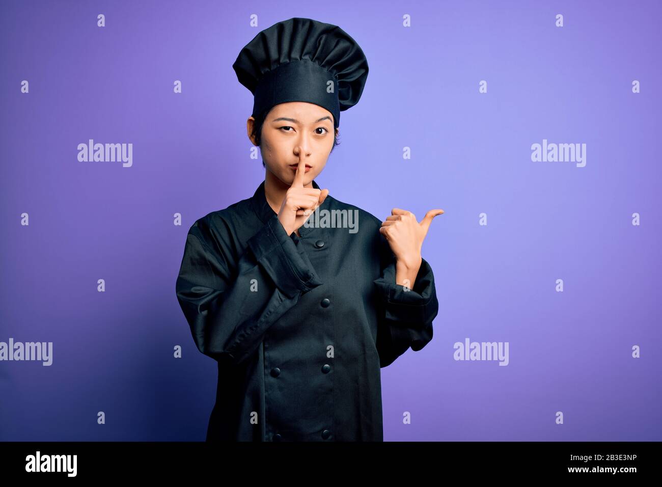 Young beautiful chinese chef woman wearing cooker uniform and hat over ...