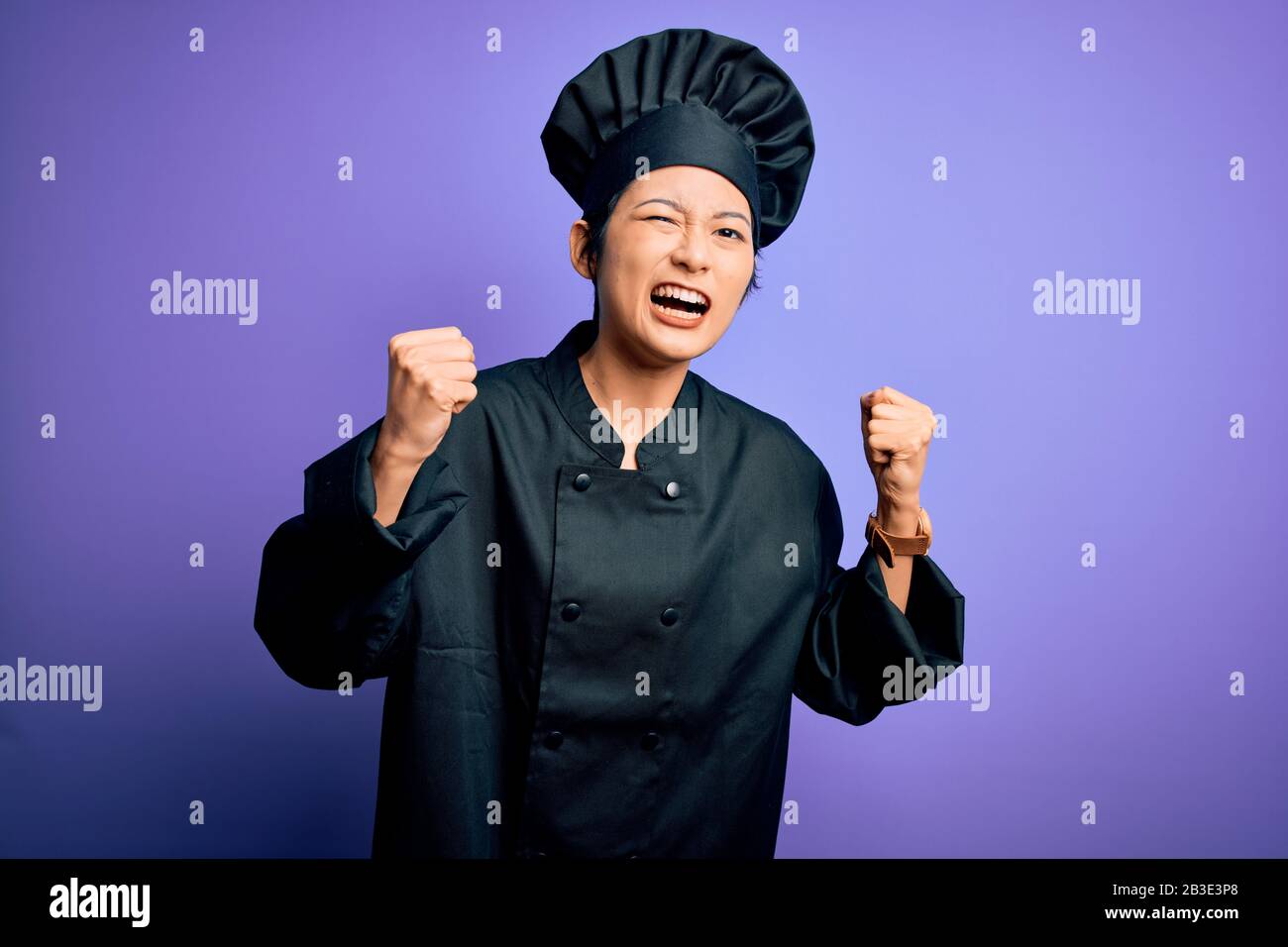Young beautiful chinese chef woman wearing cooker uniform and hat over ...