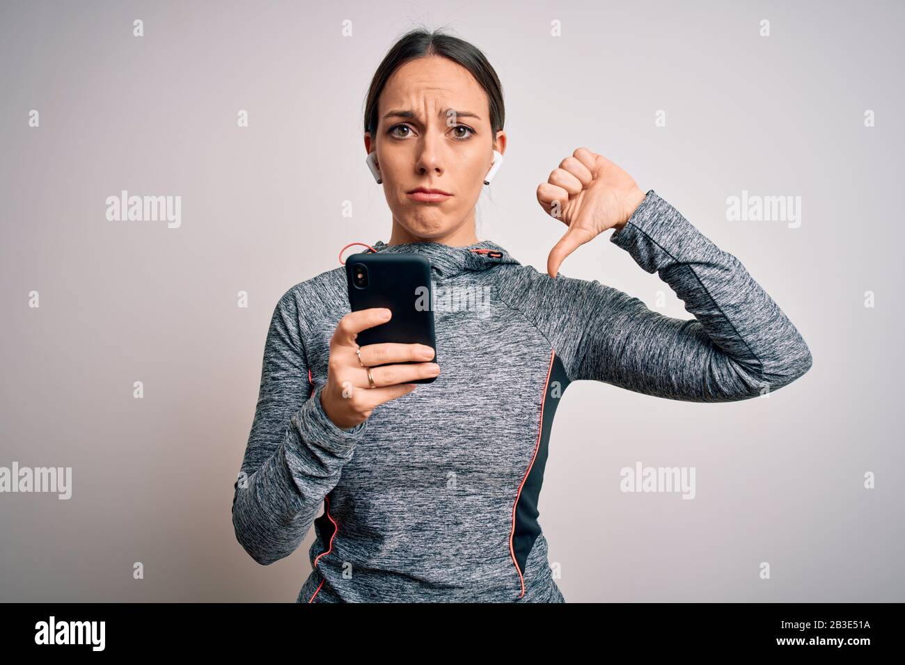 Young fitness woman wearing sport workout clothes using smartphone app ...
