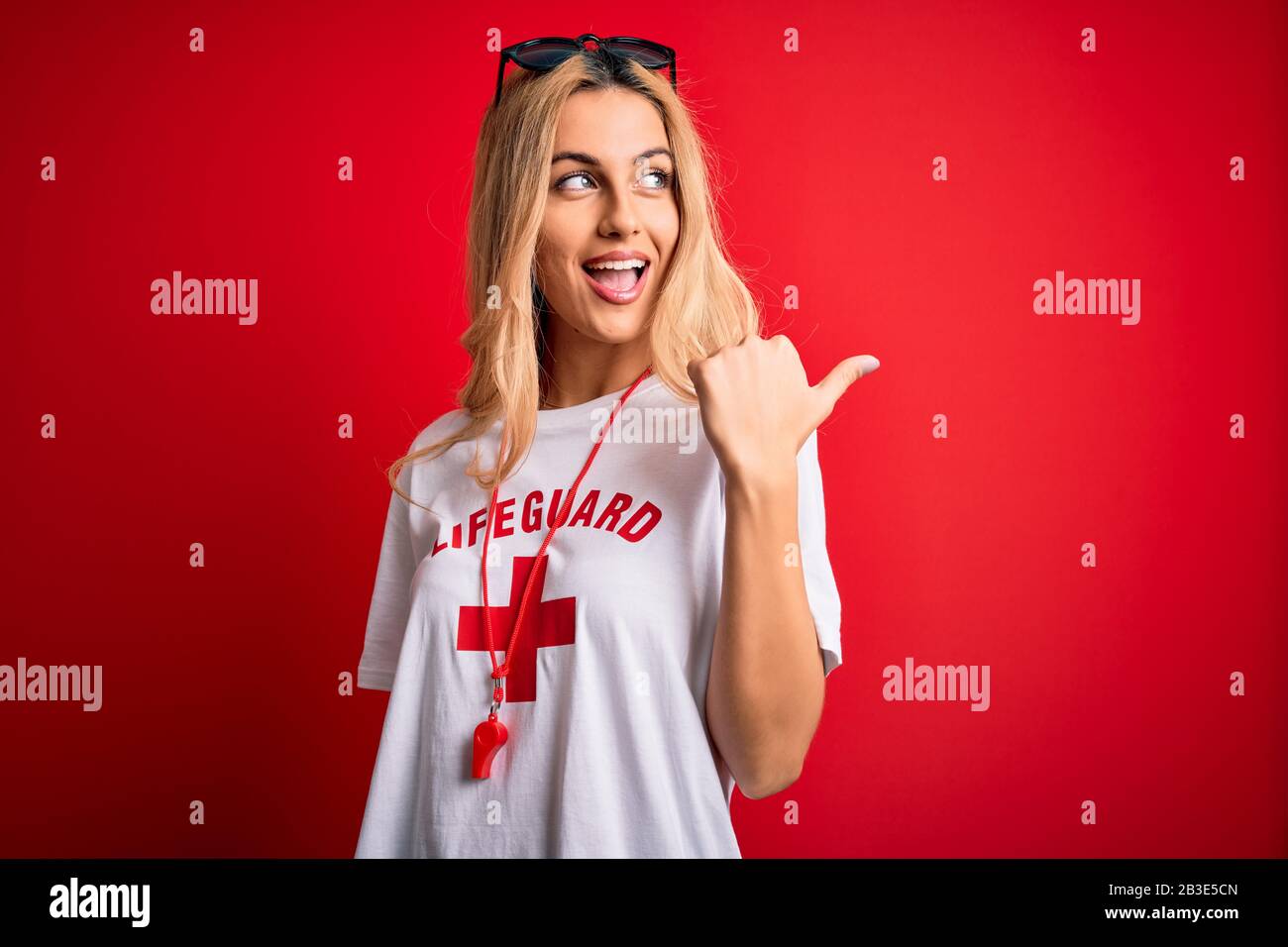 Young beautiful blonde lifeguard woman wearing t-shirt with red cross ...