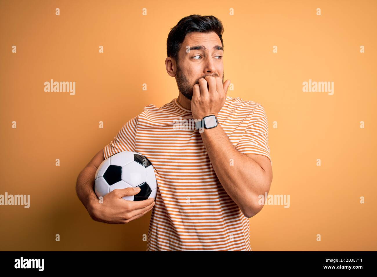 Handsome player man with beard playing soccer holding footballl ball ...