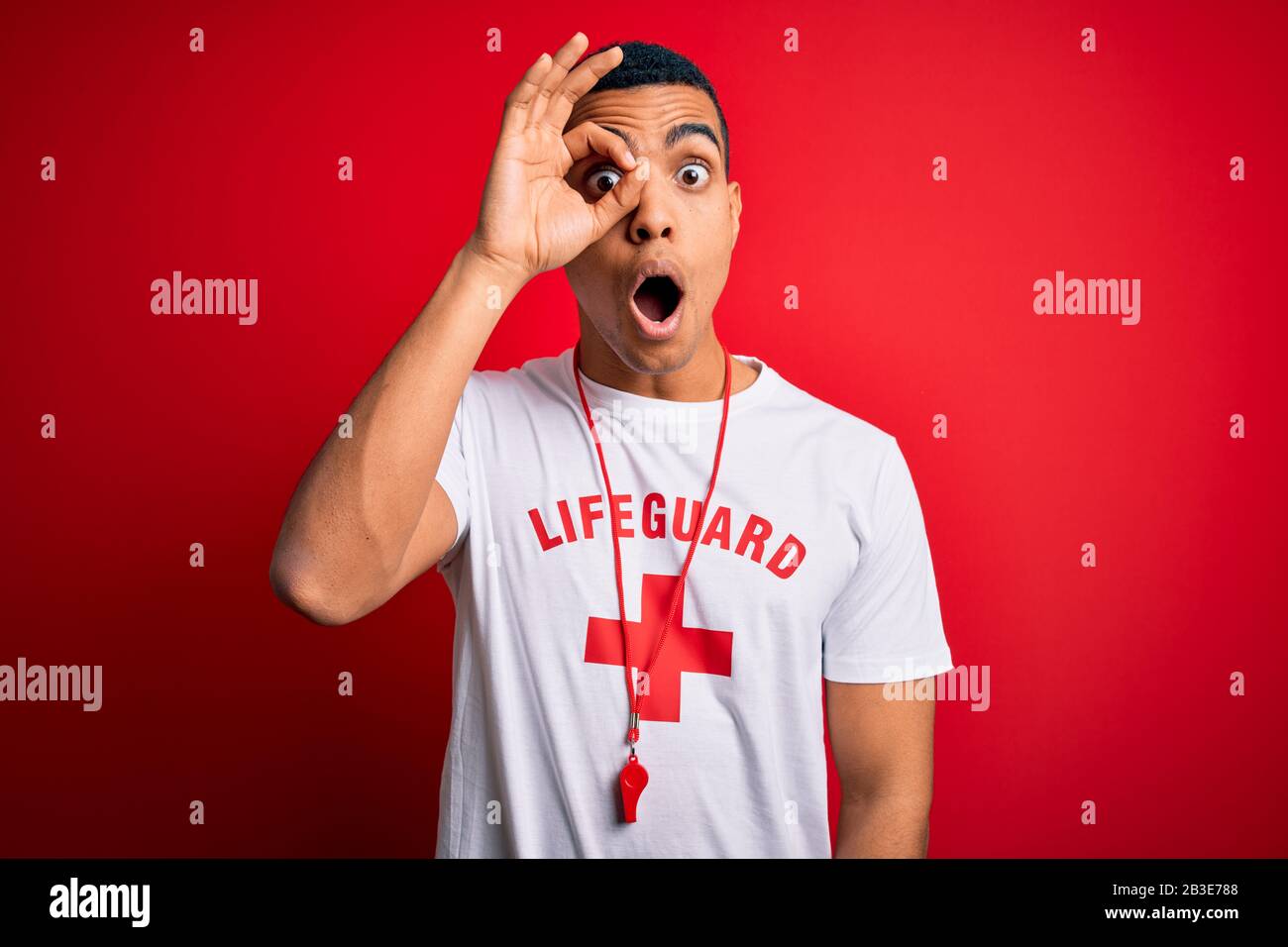 Young handsome african american lifeguard man wearing t-shirt with red ...