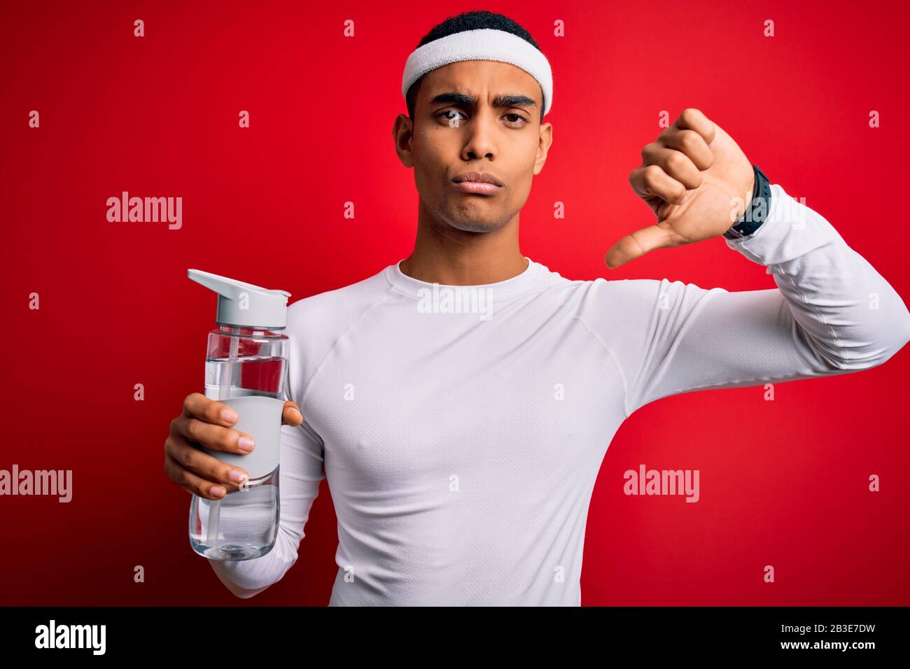 Young handsome african american sportsman wearing sportswear drinking ...