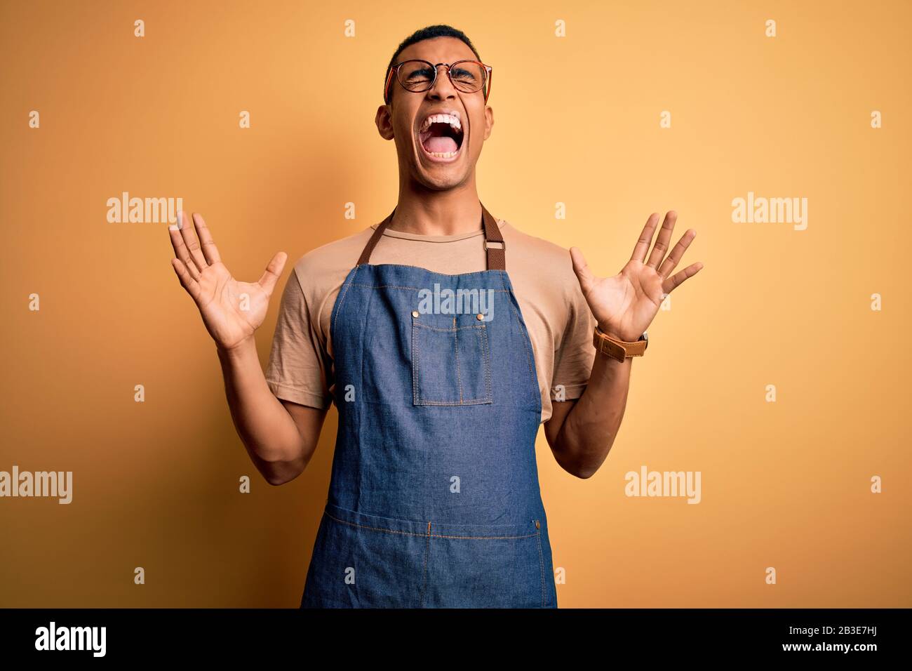 Young handsome african american shopkeeper man wearing apron over ...