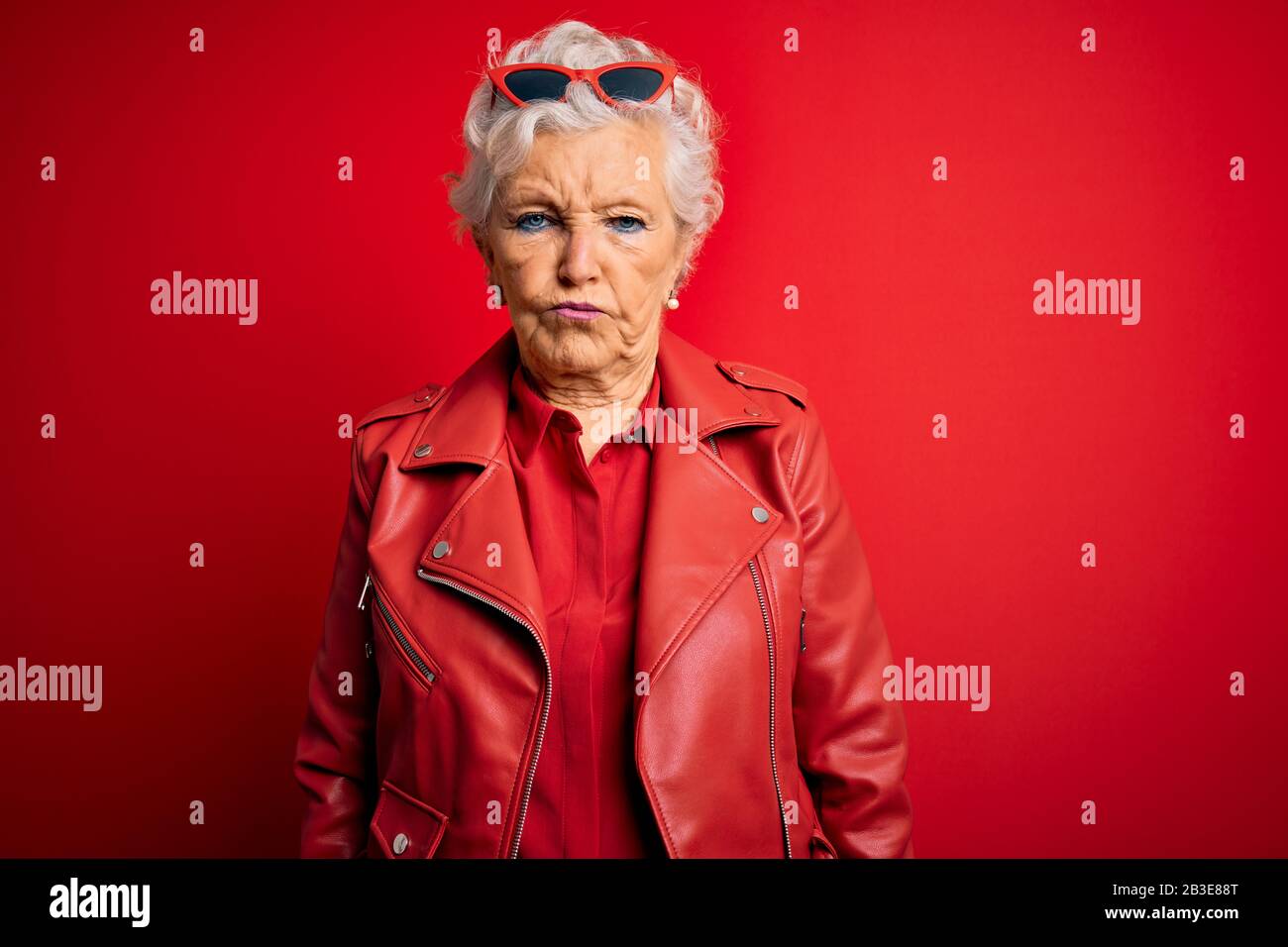Senior beautiful grey-haired woman wearing casual red jacket and ...