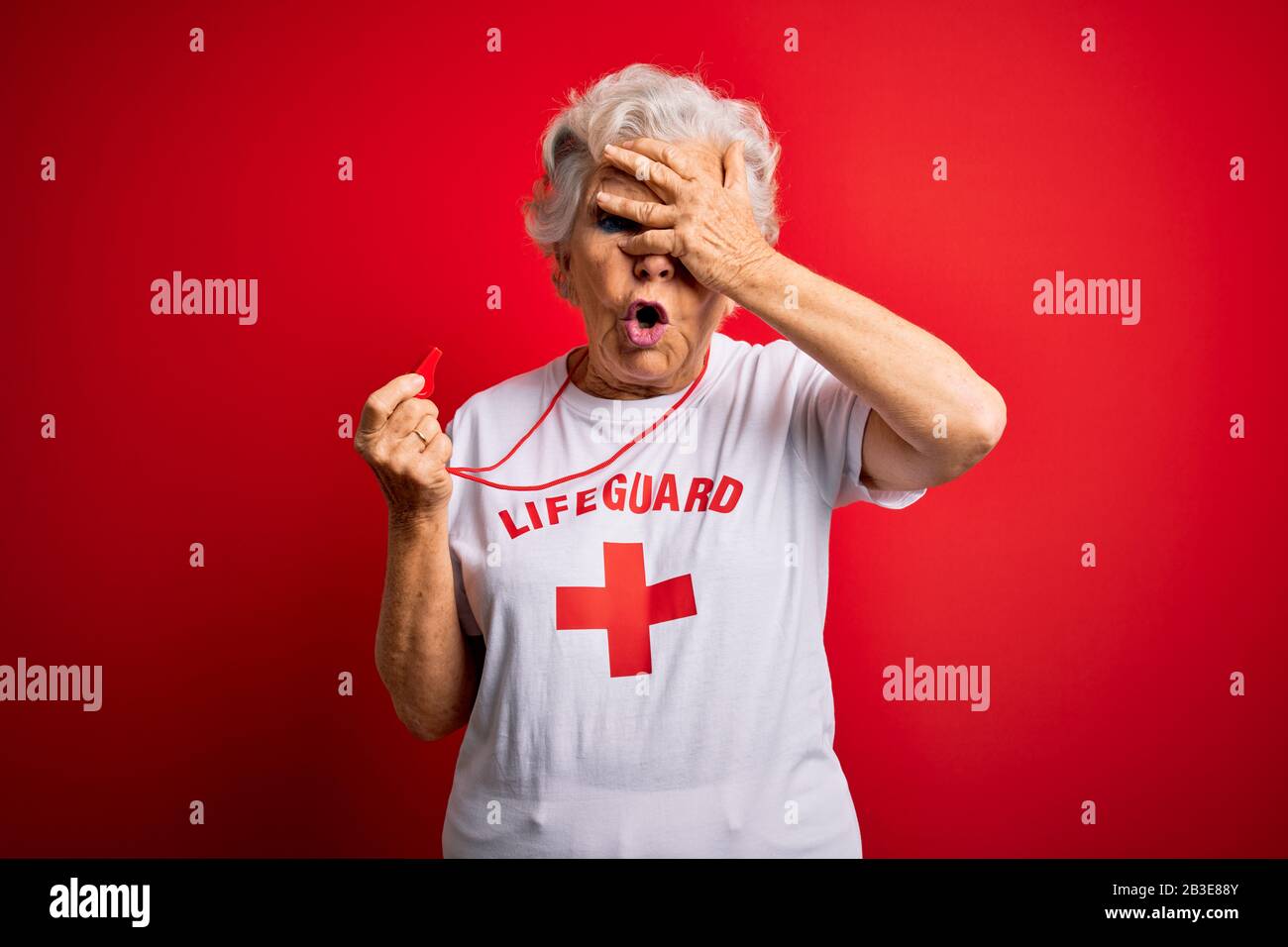 Senior beautiful grey-haired lifeguard woman wearing t-shirt with red ...