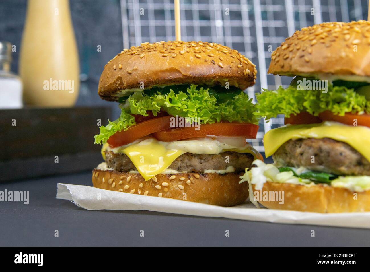 Two burgers close-up, in the background a grill Stock Photo - Alamy