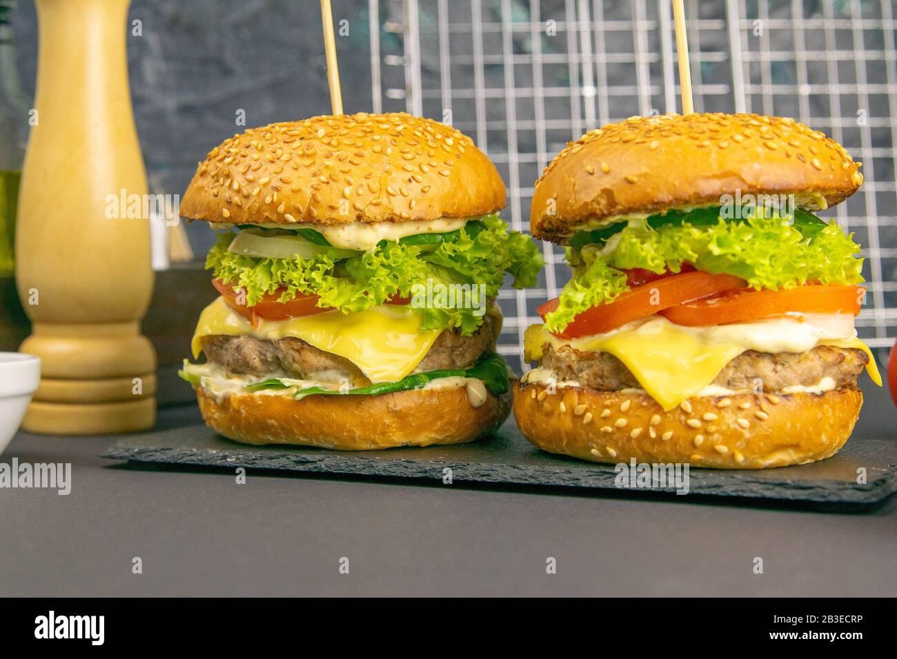 Two burgers close-up, in the background a grill Stock Photo - Alamy