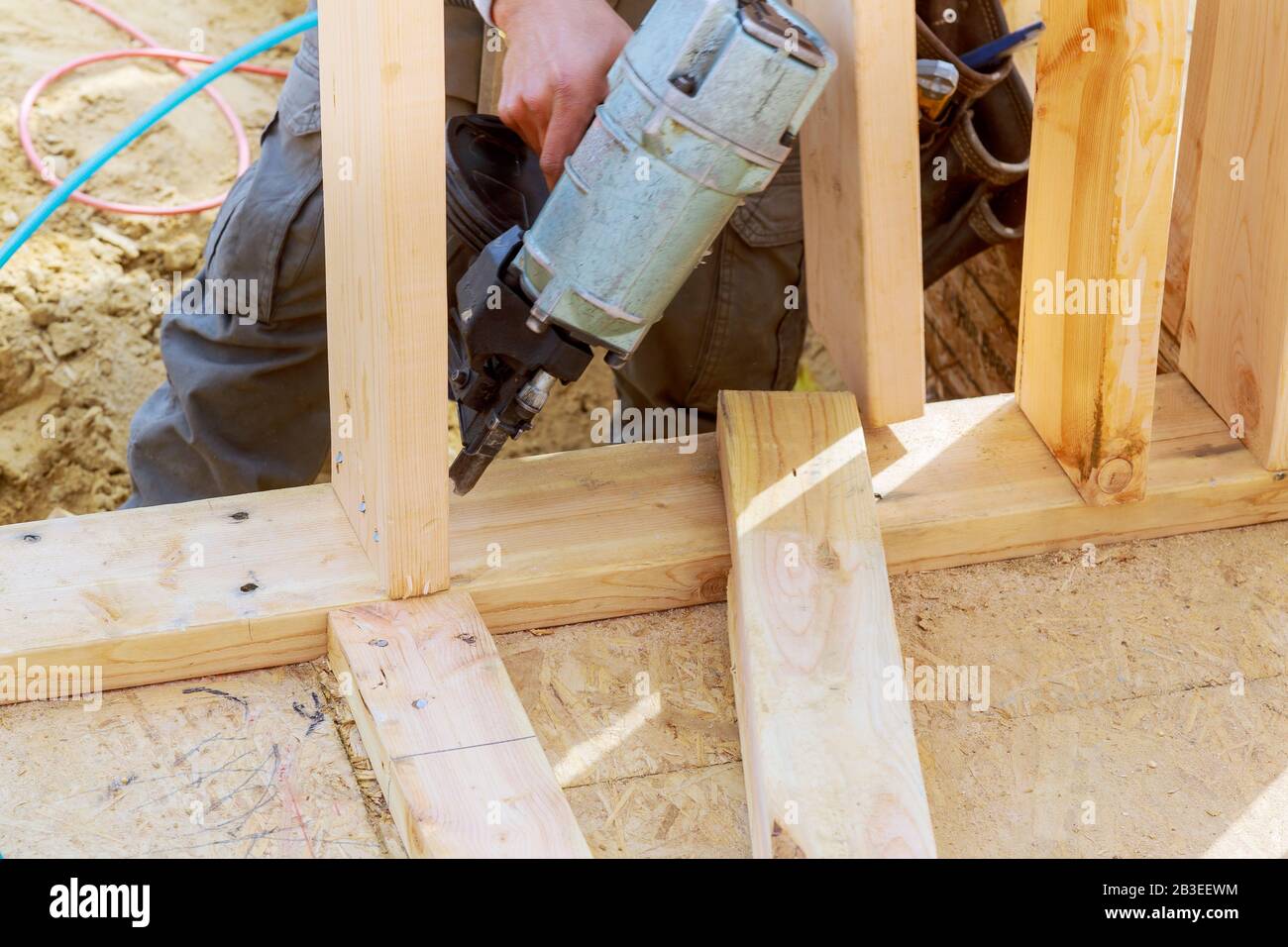 Building contractor worker nailing timber with air nail gun Stock Photo ...