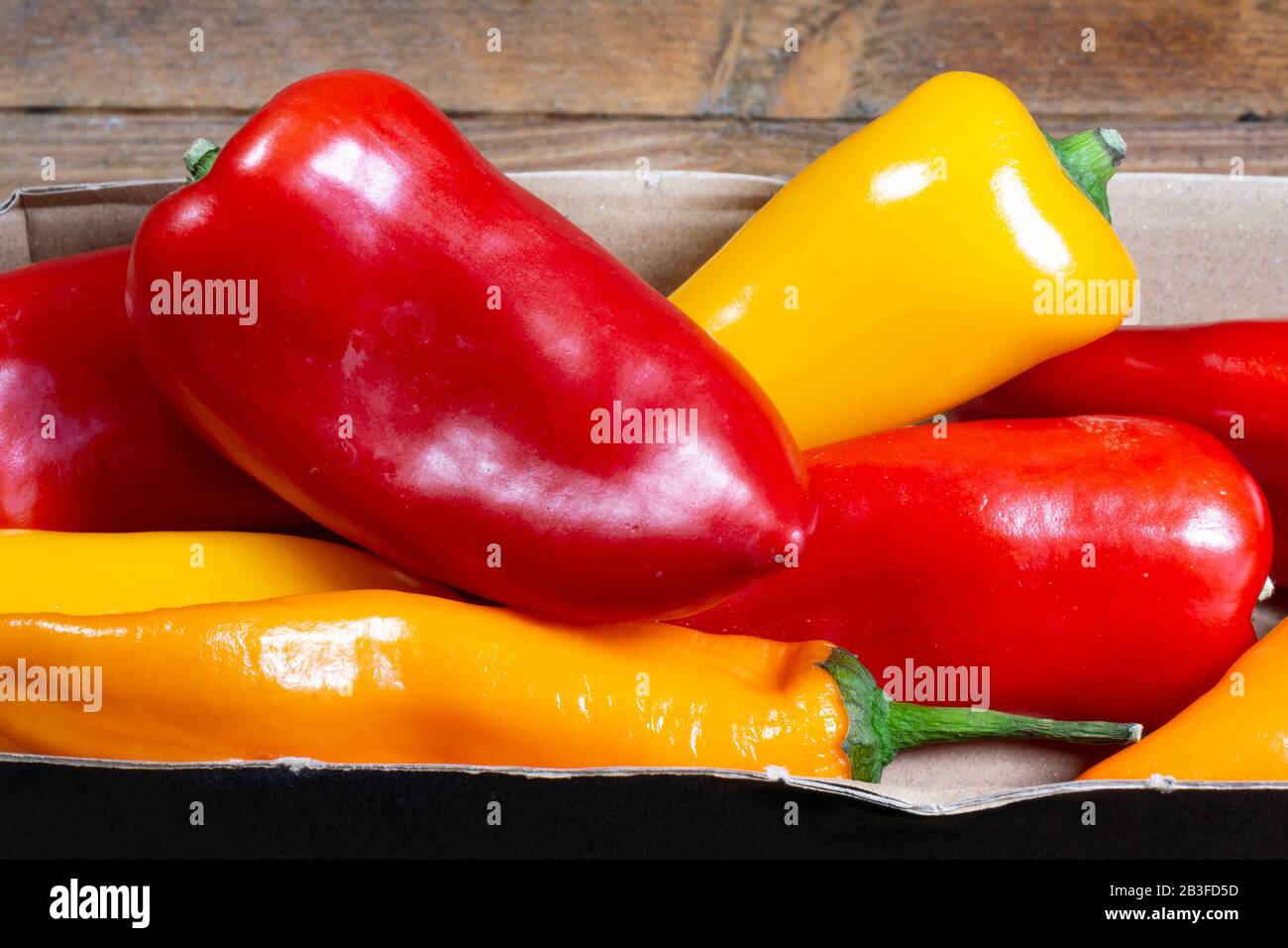 Red, yellow and orange peppers in a cardboard tray Stock Photo - Alamy