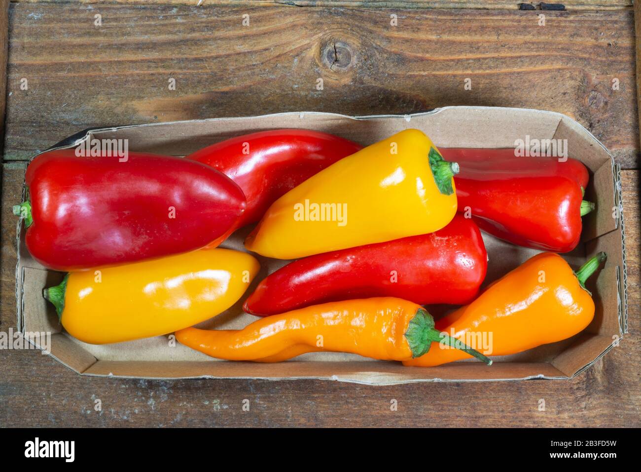 Red, yellow and orange peppers in a cardboard tray Stock Photo - Alamy