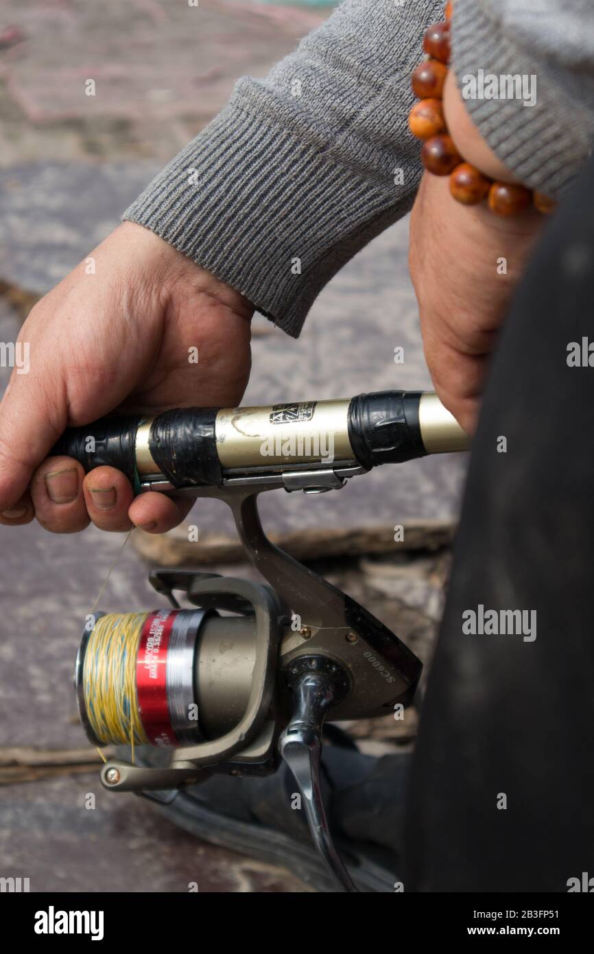 A man sitting with fishing rod and wait Stock Photo - Alamy