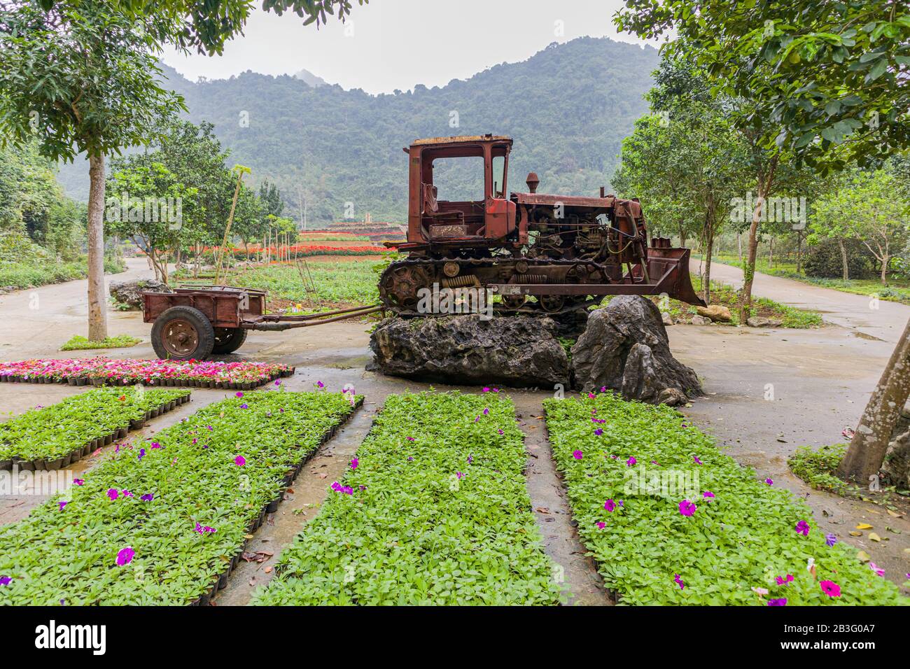 An old tractor monument in a park with green garden beds Stock Photo ...
