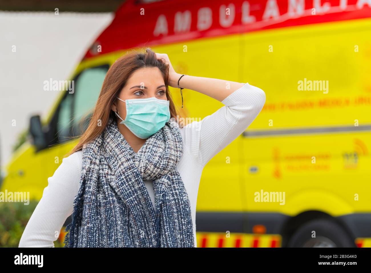 Young female wearing a mask looking worried Stock Photo - Alamy