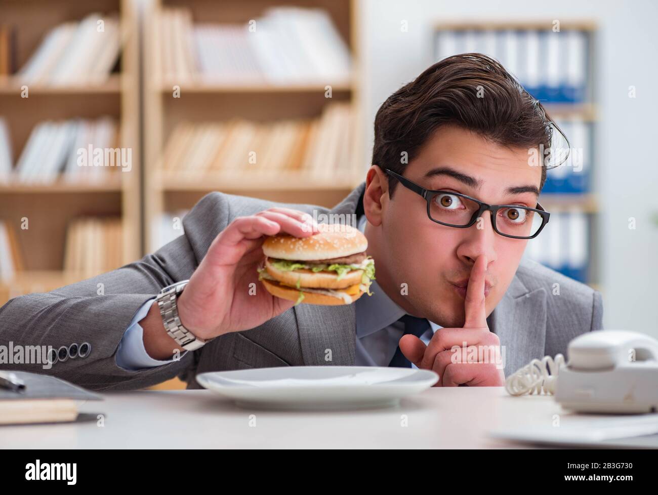 The hungry funny businessman eating junk food sandwich Stock Photo - Alamy