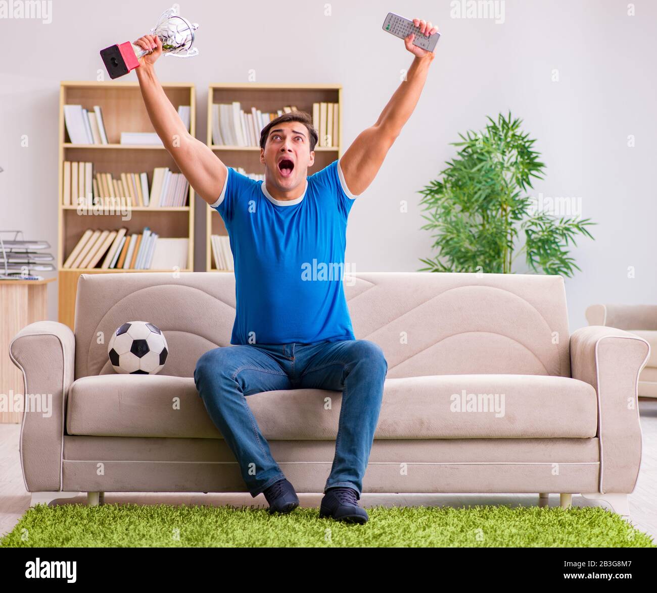 The man watching football at home sitting in couch Stock Photo - Alamy