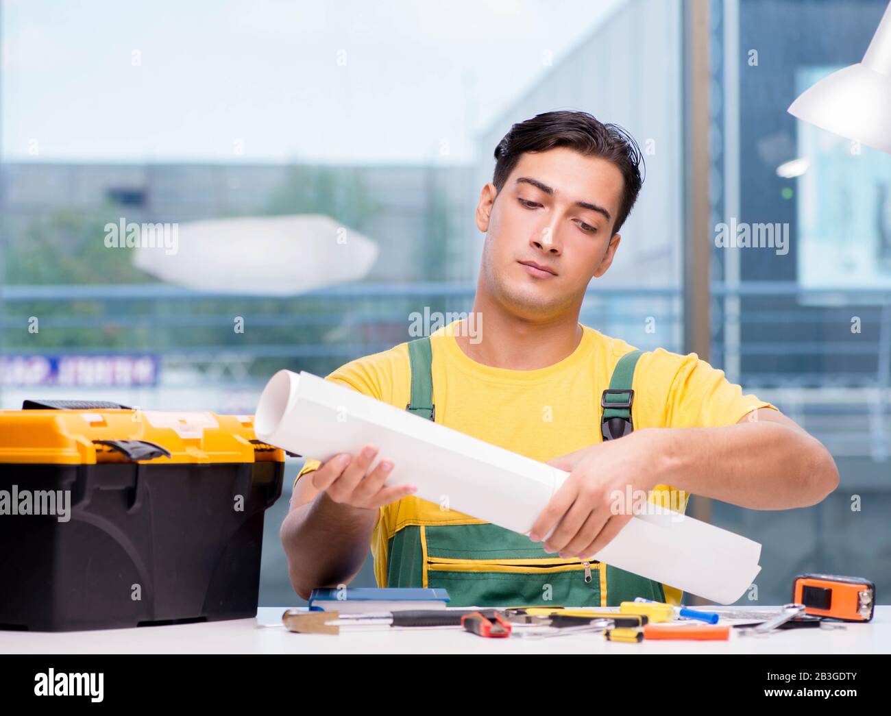 The construction worker sitting at the desk Stock Photo - Alamy