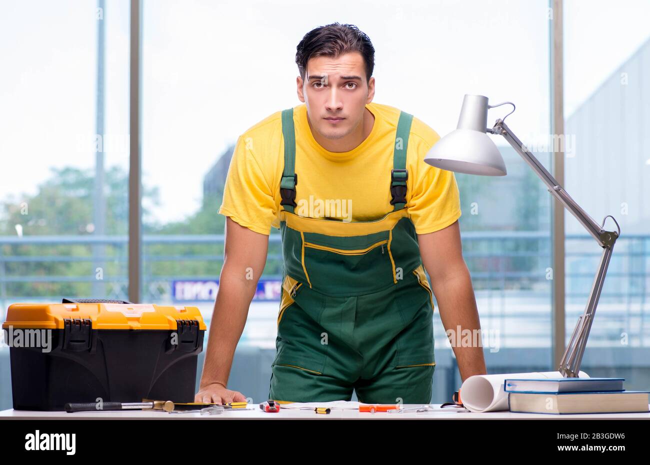 The construction worker sitting at the desk Stock Photo - Alamy