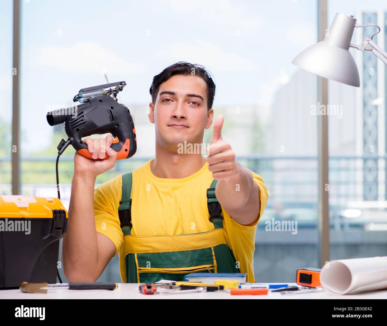 The construction worker sitting at the desk Stock Photo - Alamy