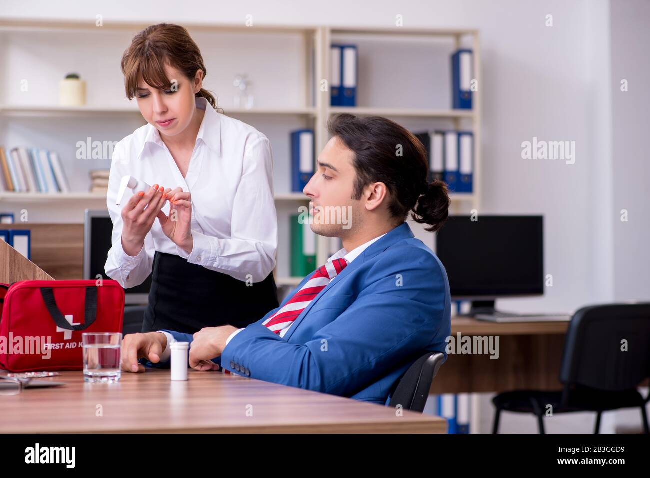 Employee receiving first aid in office Stock Photo - Alamy