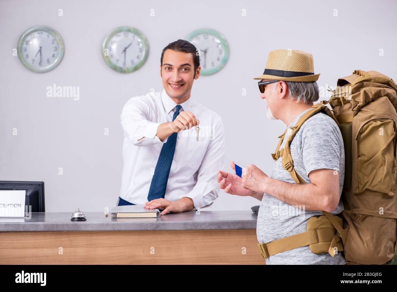 Old backpacker at the hotel reception Stock Photo - Alamy