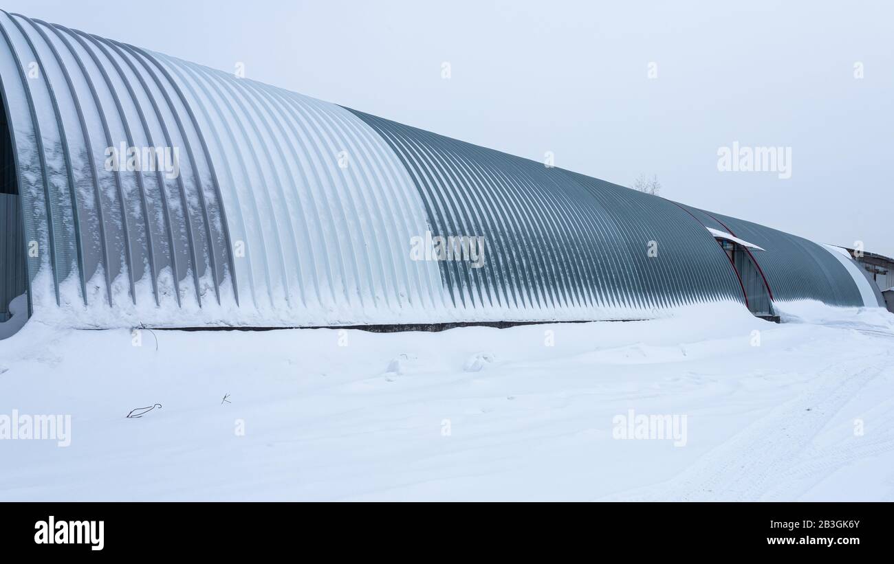 A large metal industrial warehouse for storing goods in winter day ...