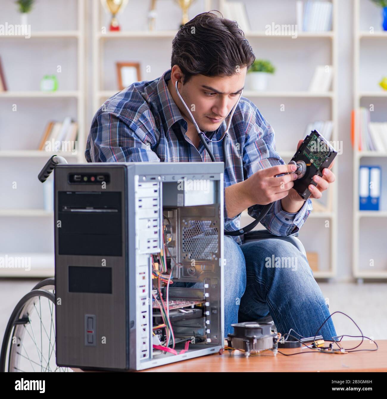 The computer repairman on wheelchair working Stock Photo - Alamy