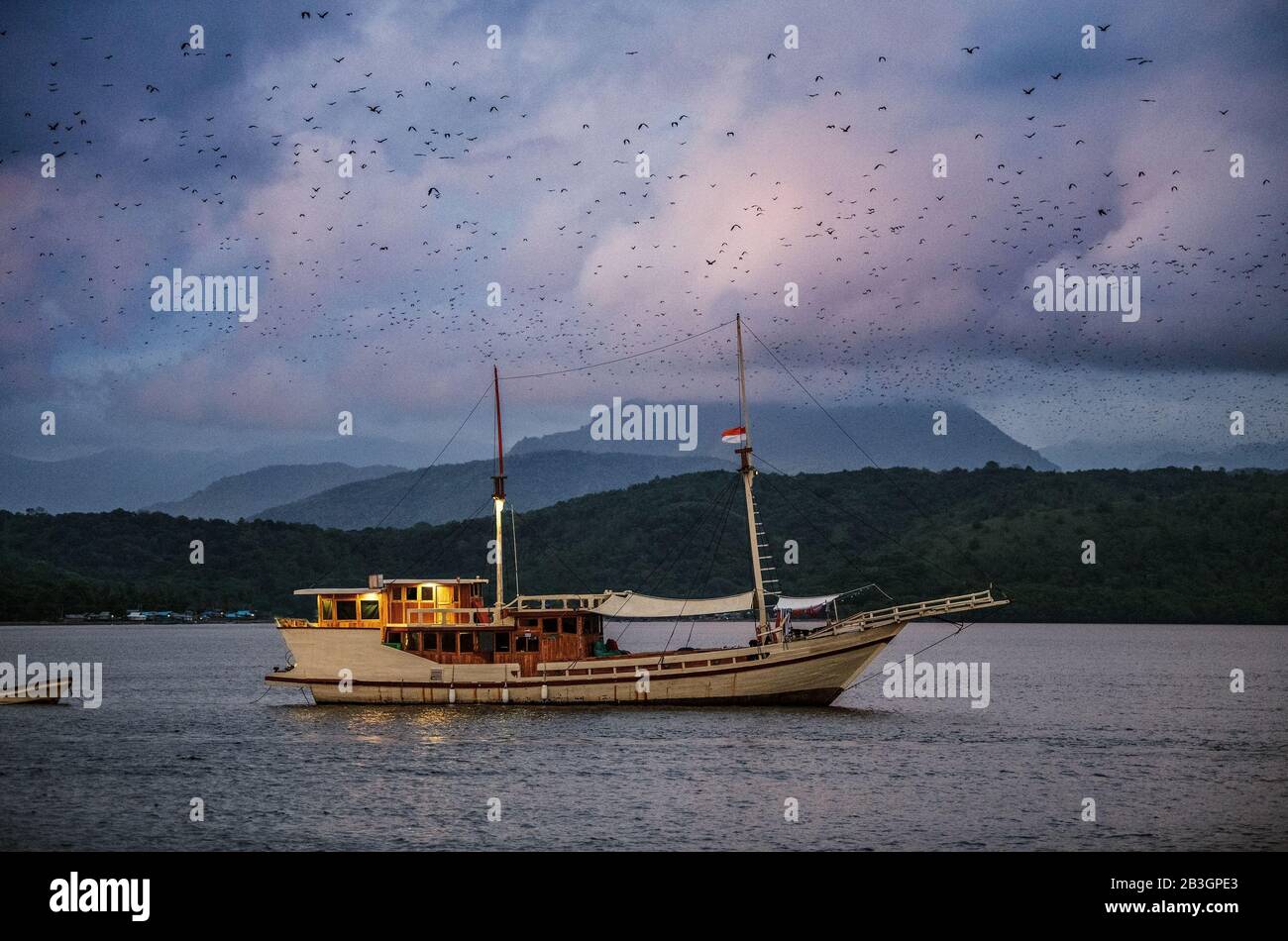 Indonesian traditional ship in the ocean at sunset twilight. Ocean and ...