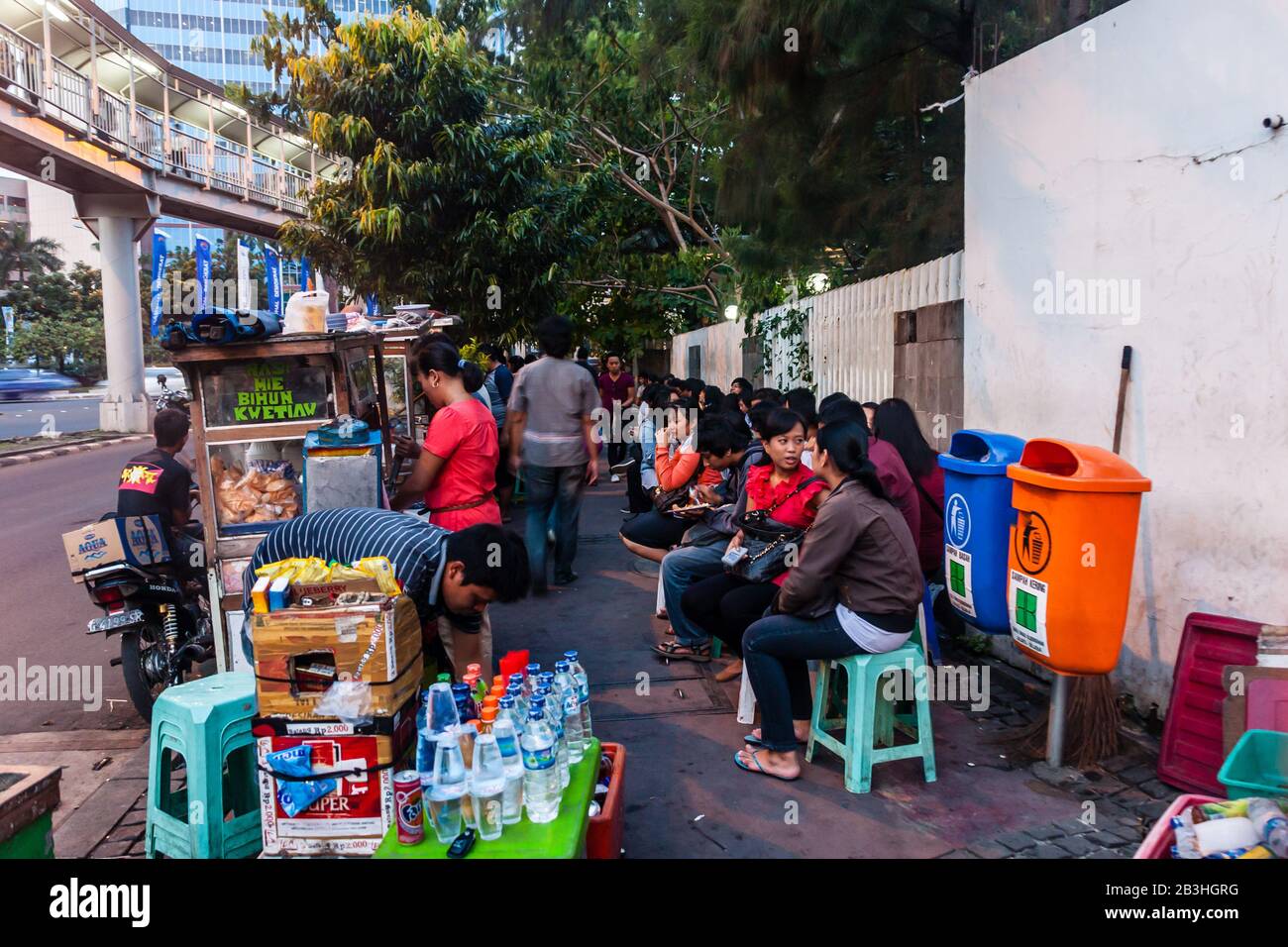 A crowded street in Jakarta with mobile street food kiosks, Indonesia ...