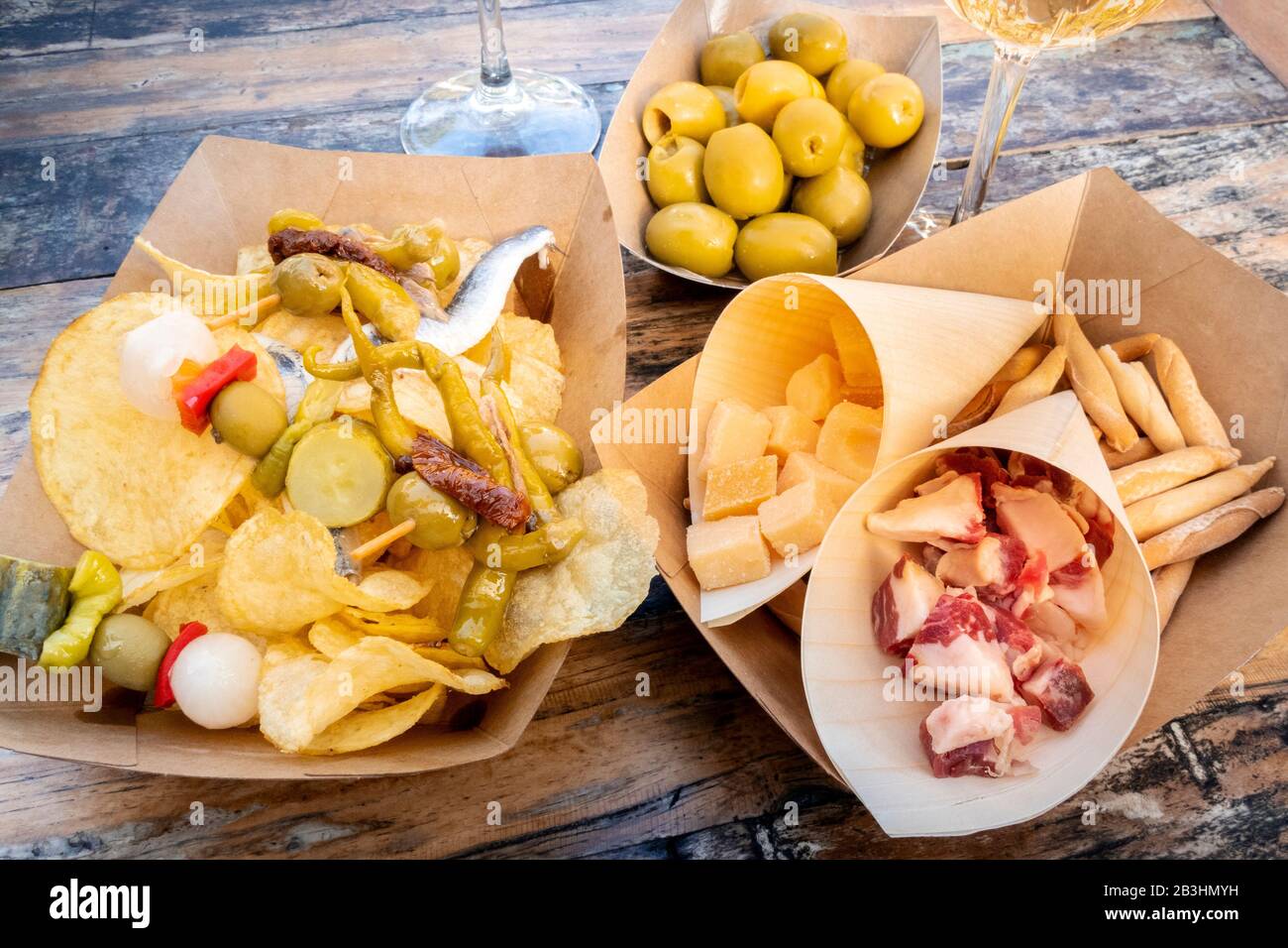 Tapas and pinchos. Spicy gildas, cheese, jamon and olives on a wooden ...