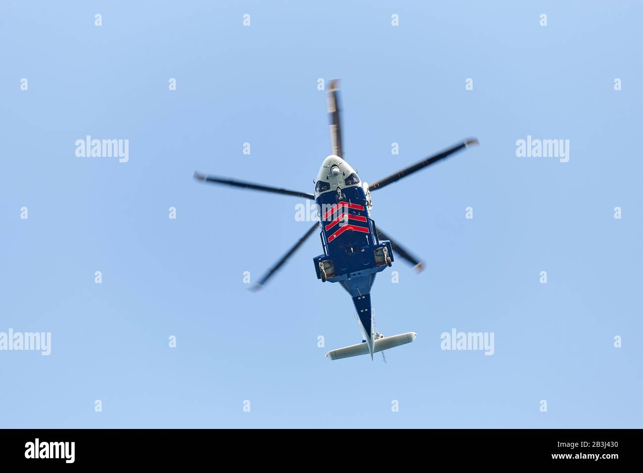 Helicopter flying under a blue sky from below. Air transport Stock ...