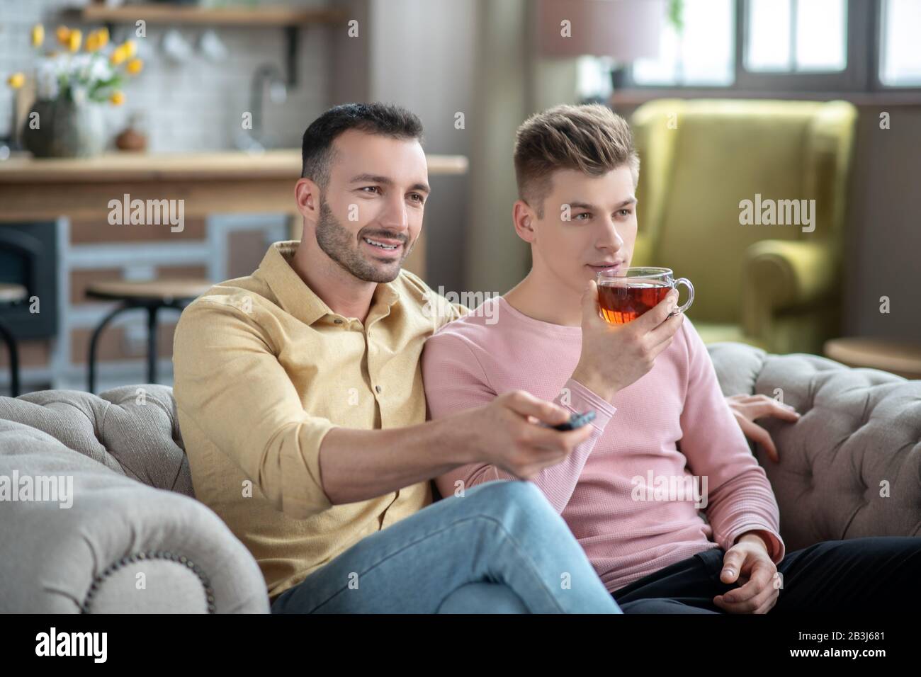 Homosexual couple men watching television hi-res stock photography and ...