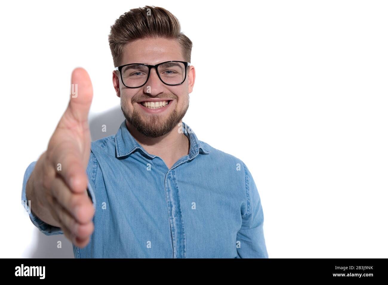 smiling young smart casual man greets with a handshake on white ...