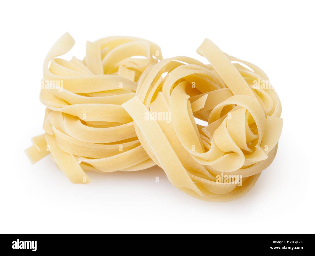 Uncooked nests of tagliatelle pasta isolated on white background with ...