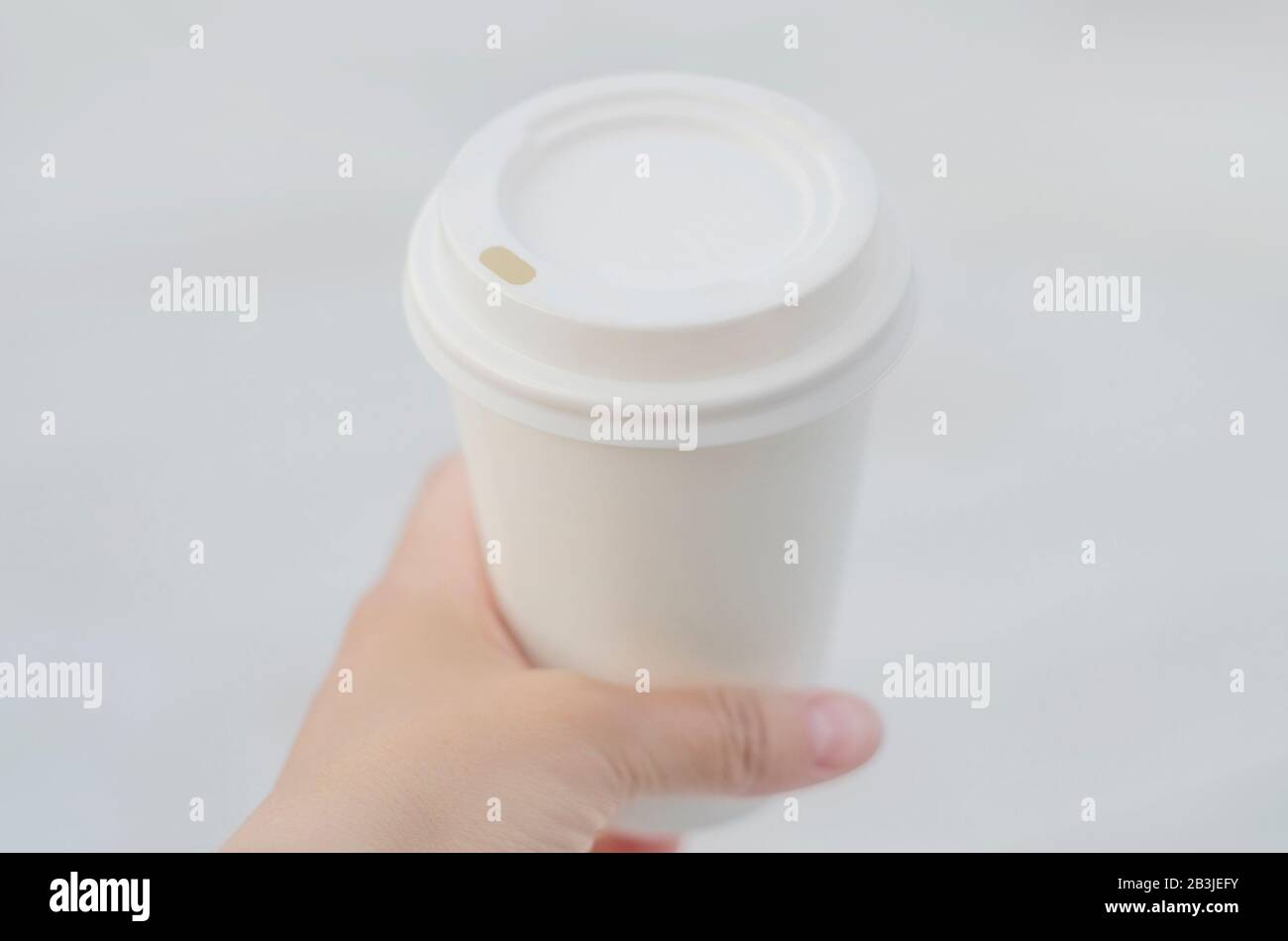 Female hand holding paper coffee cup. Top side view Stock Photo - Alamy