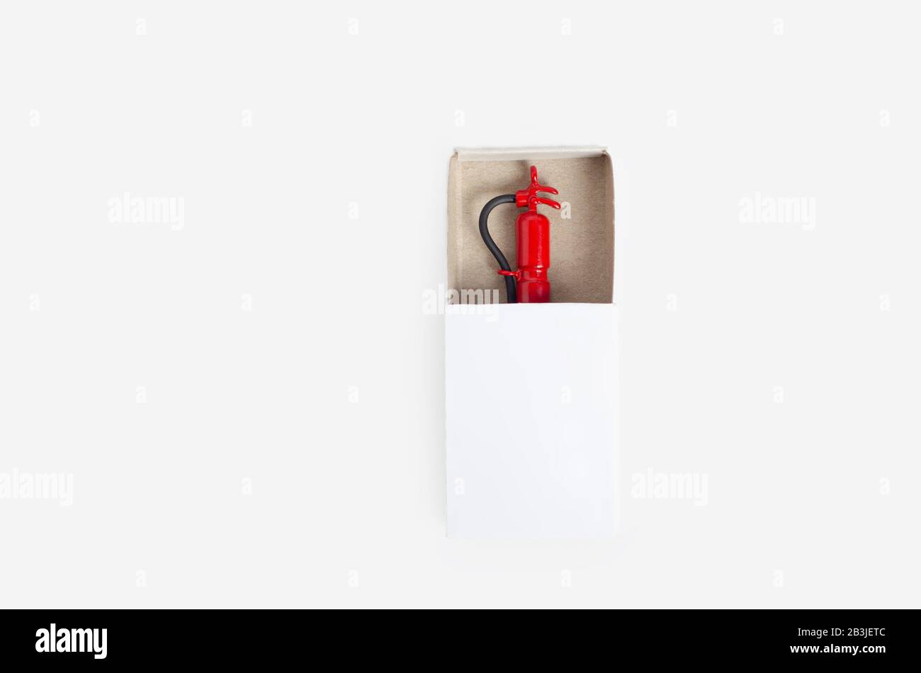 Tiny fire extinguisher inside a white match box, top view, isolated on ...