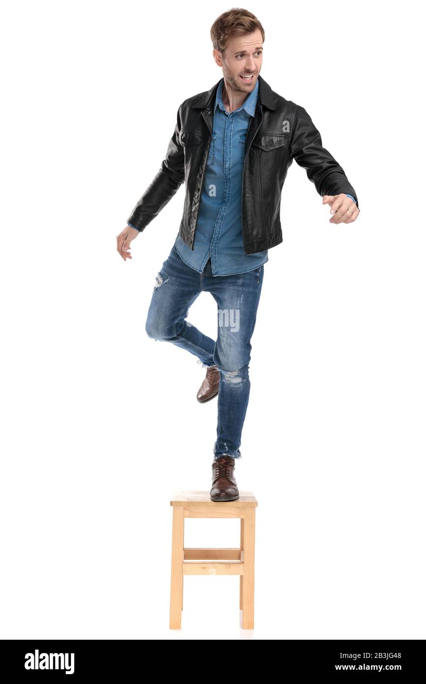 good looking casual man with black leather jacket is standing in one ...