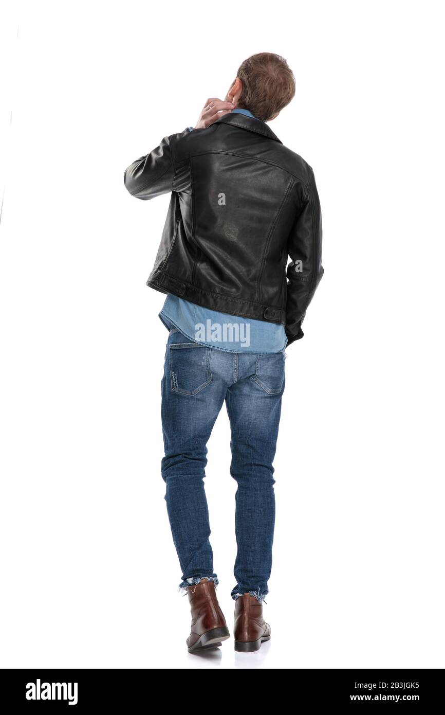 rear view of a casual man standing and scratching his neck pensive on ...