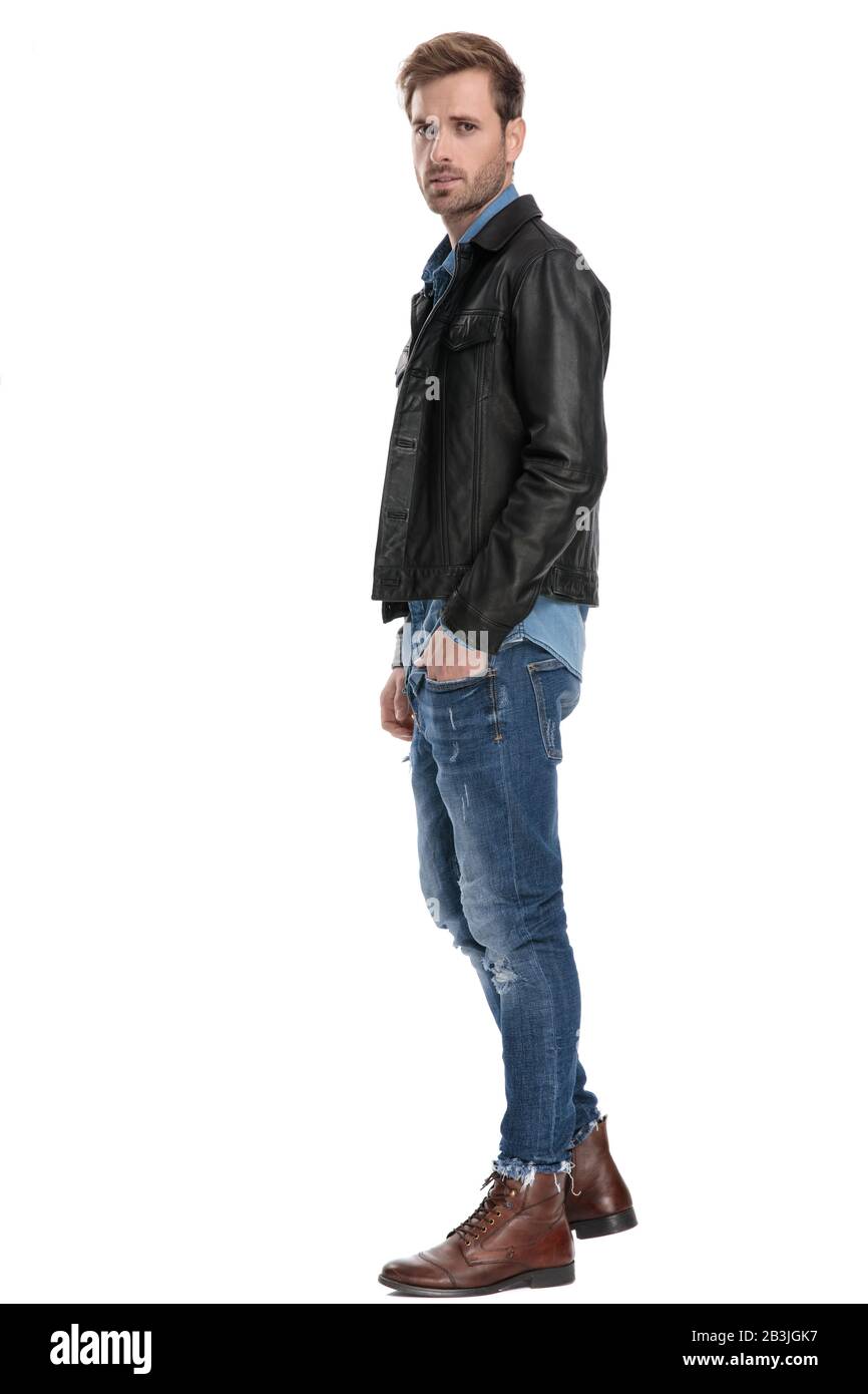 side view of a beautiful casual man with black leather jacket standing ...