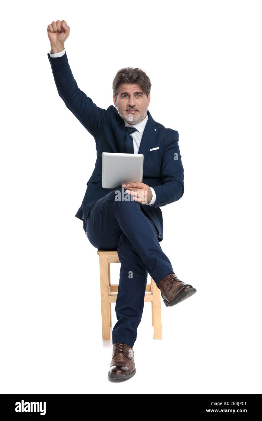 beautiful formal business man with navy suit is sitting with legs ...