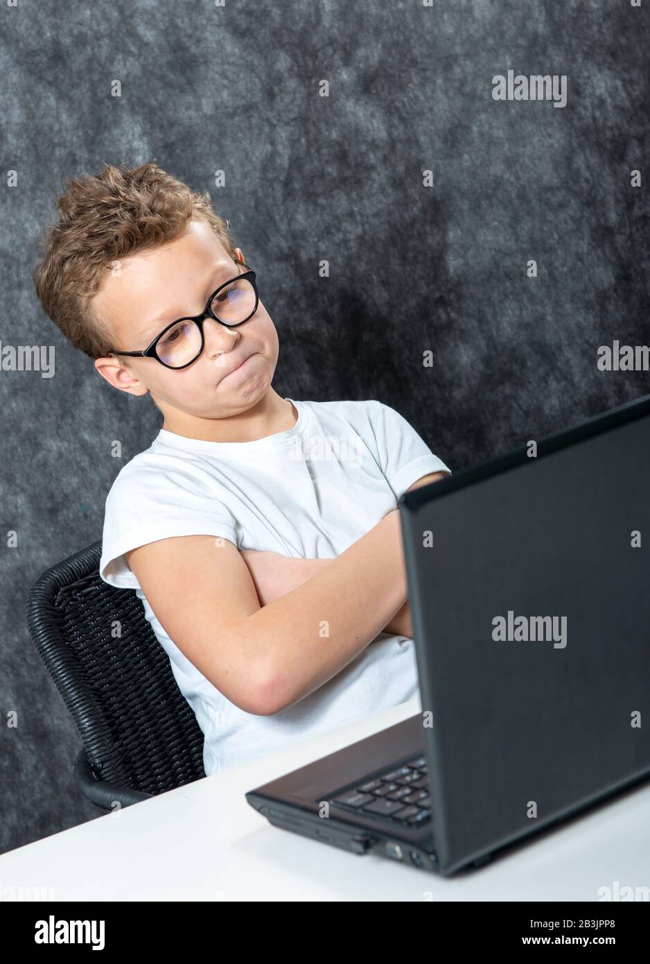 serious boy sitting with a laptop computer Stock Photo - Alamy