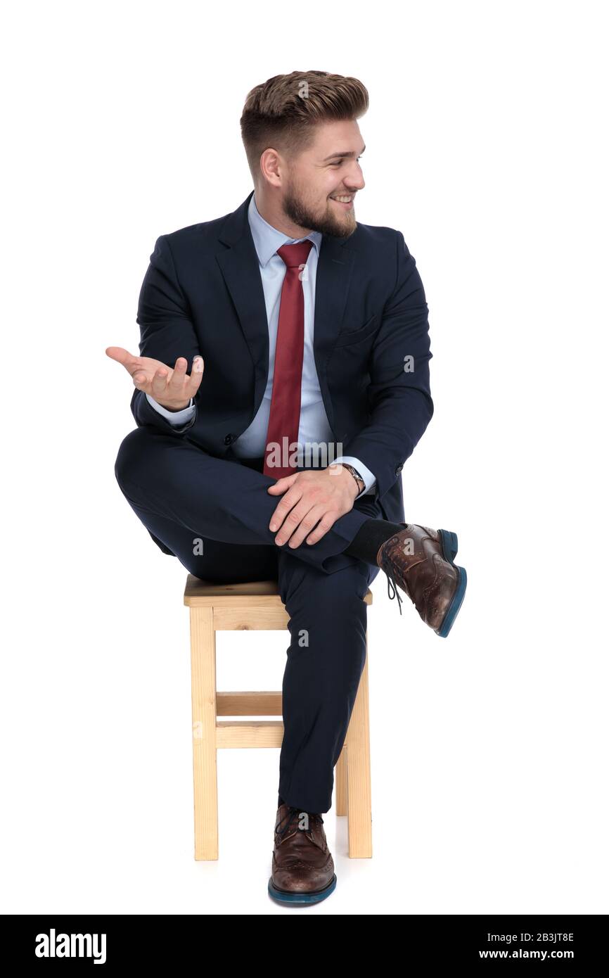 happy young businessman looking to side, talking and asking questions ...