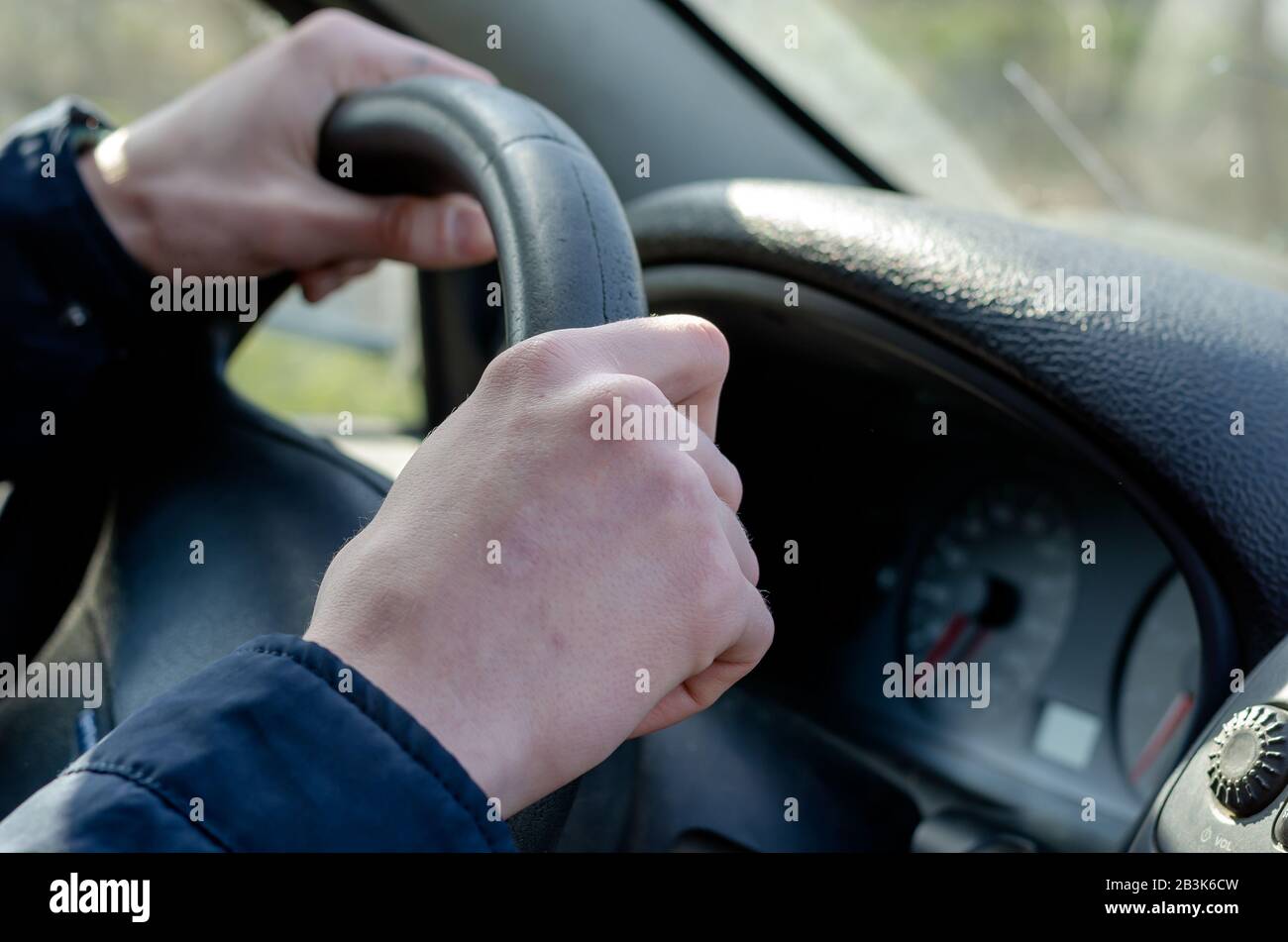 Hands of a taxi driver on the steering wheel. A young taxi driver holds ...