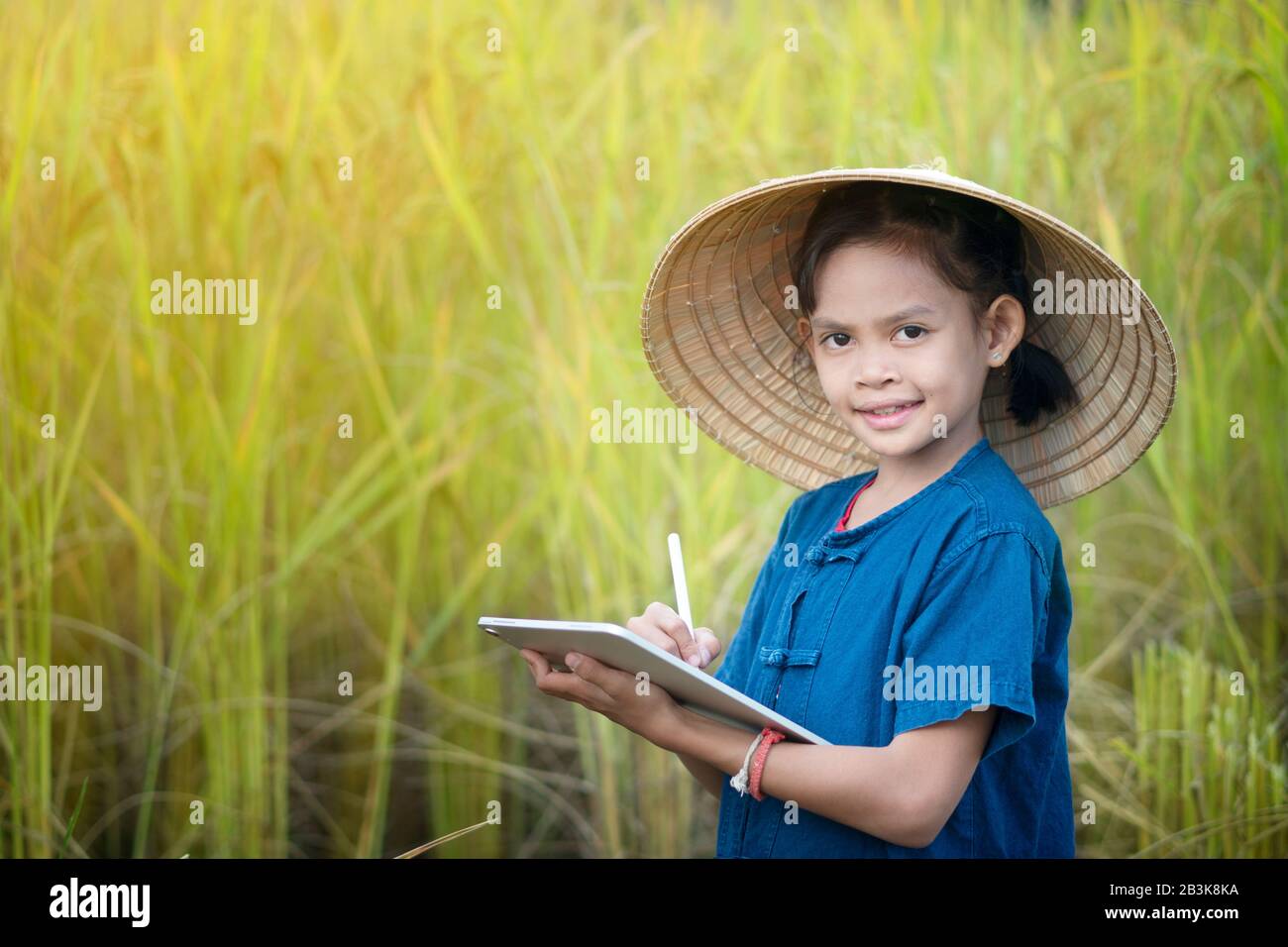 Little farmer holding tablet computer in rice field,smart farm concept ...