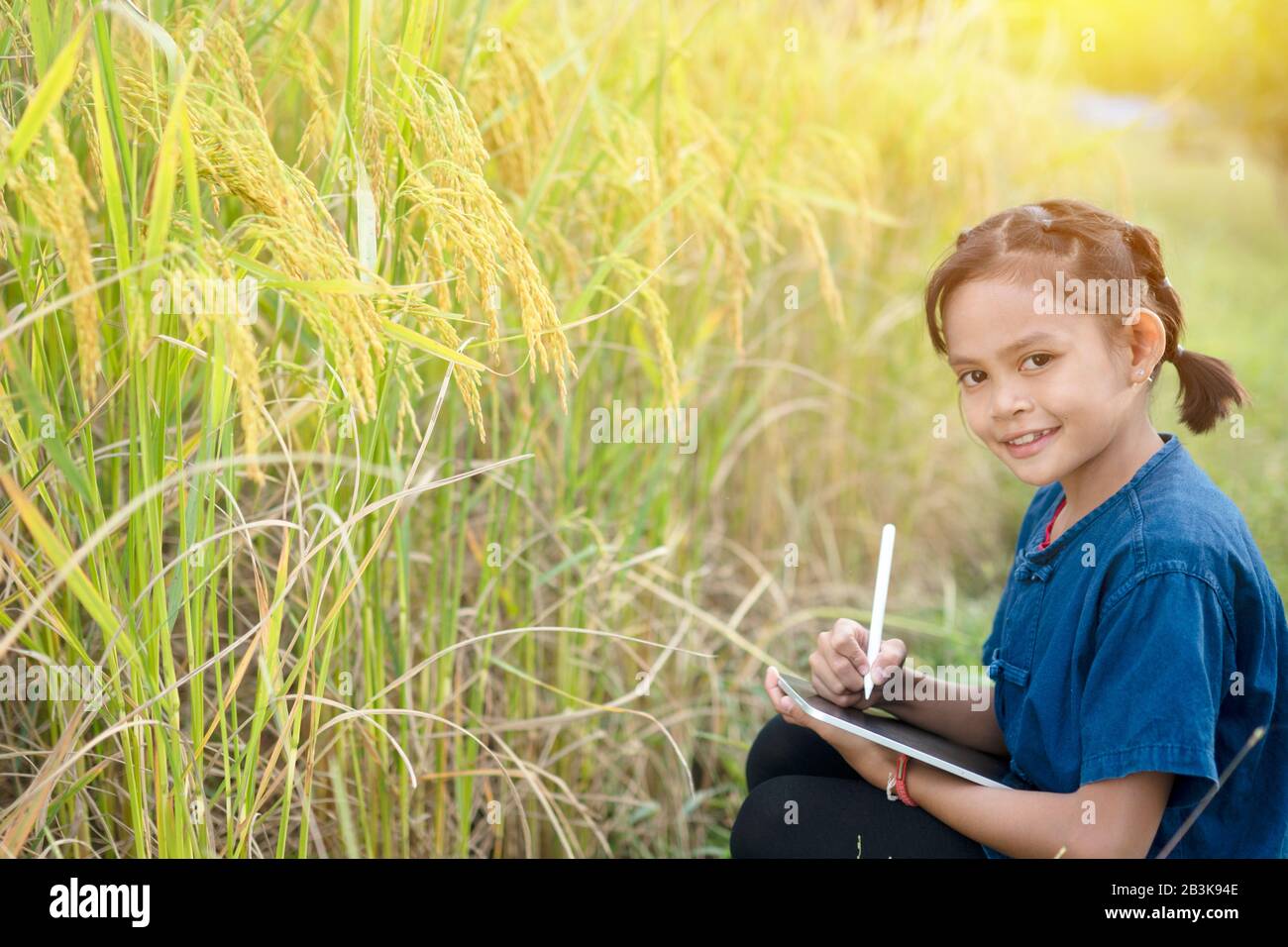 Little farmer holding tablet computer in rice field,smart farm concept ...
